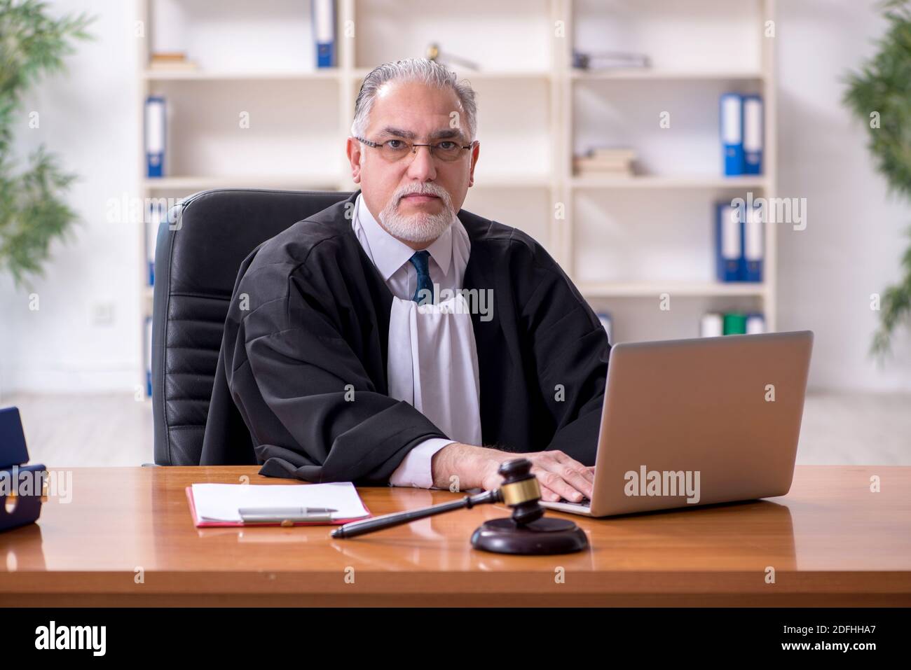 Old male judge working in the courthouse Stock Photo - Alamy