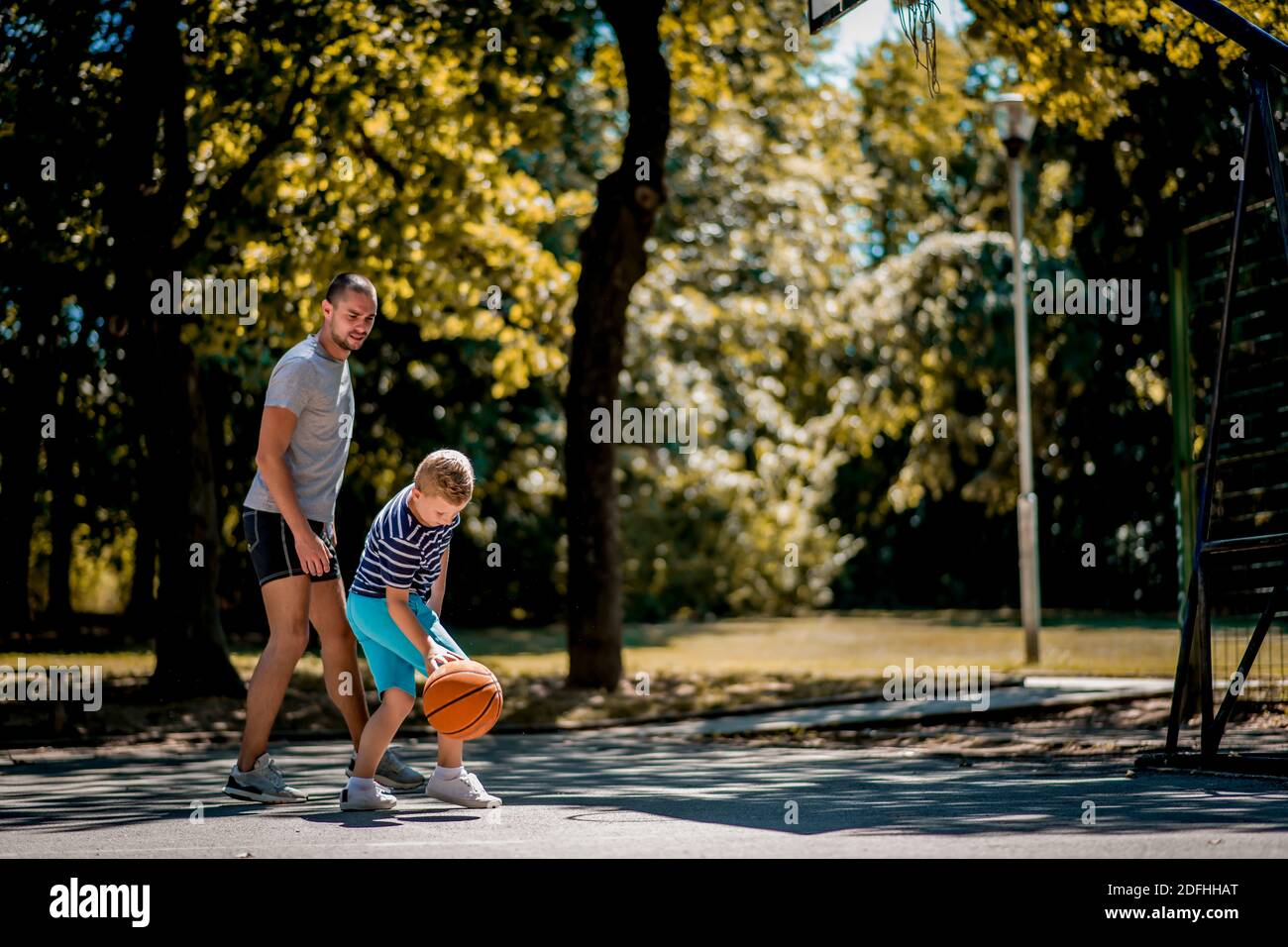 Cute blond boy practicing basketball with his coach Stock Photo - Alamy