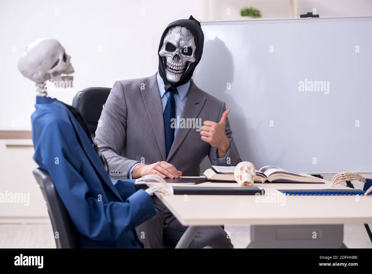 Funny business meeting with the devil and skeletons Stock Photo - Alamy
