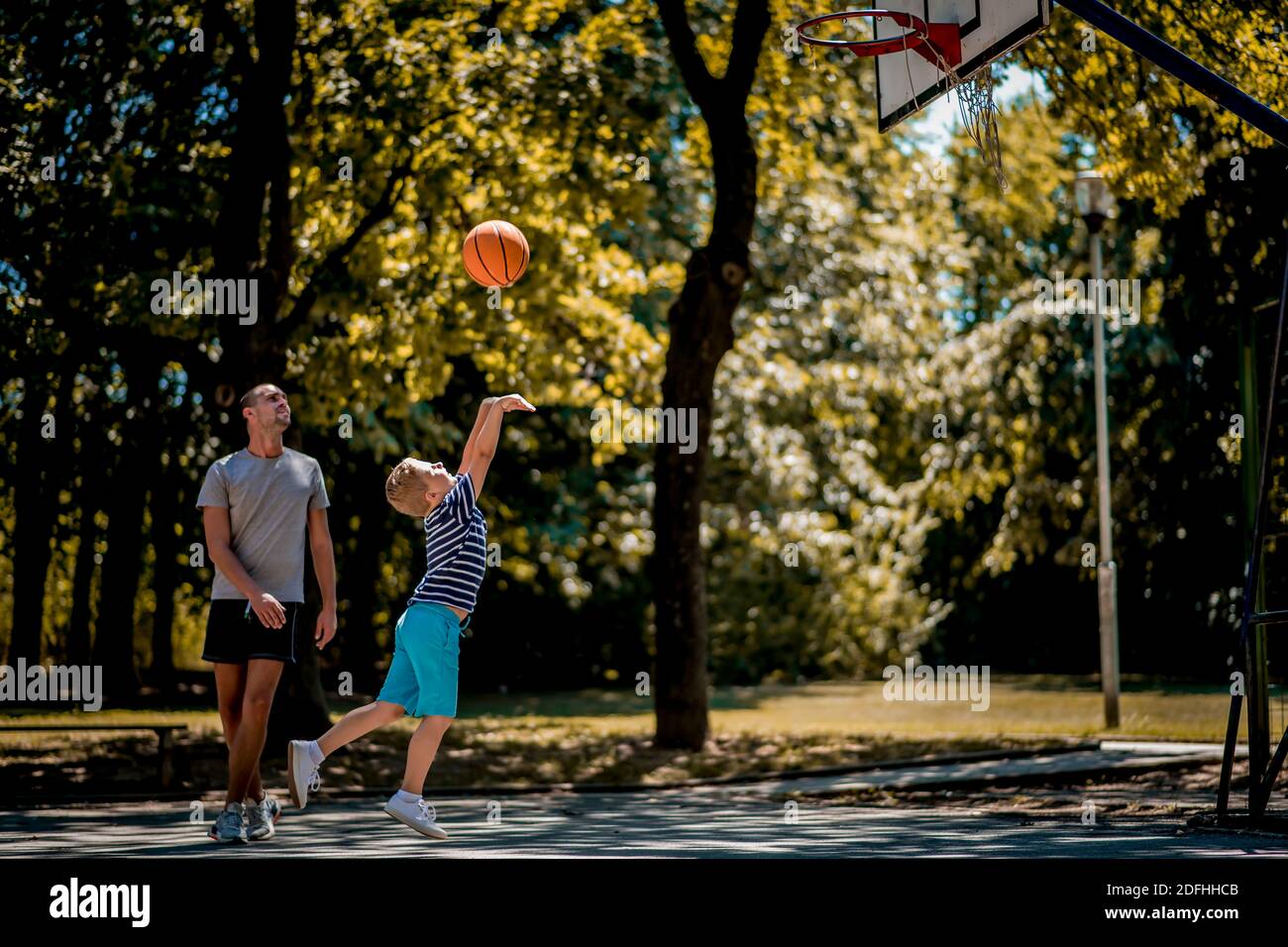 Cute blond boy practicing basketball with his coach Stock Photo - Alamy