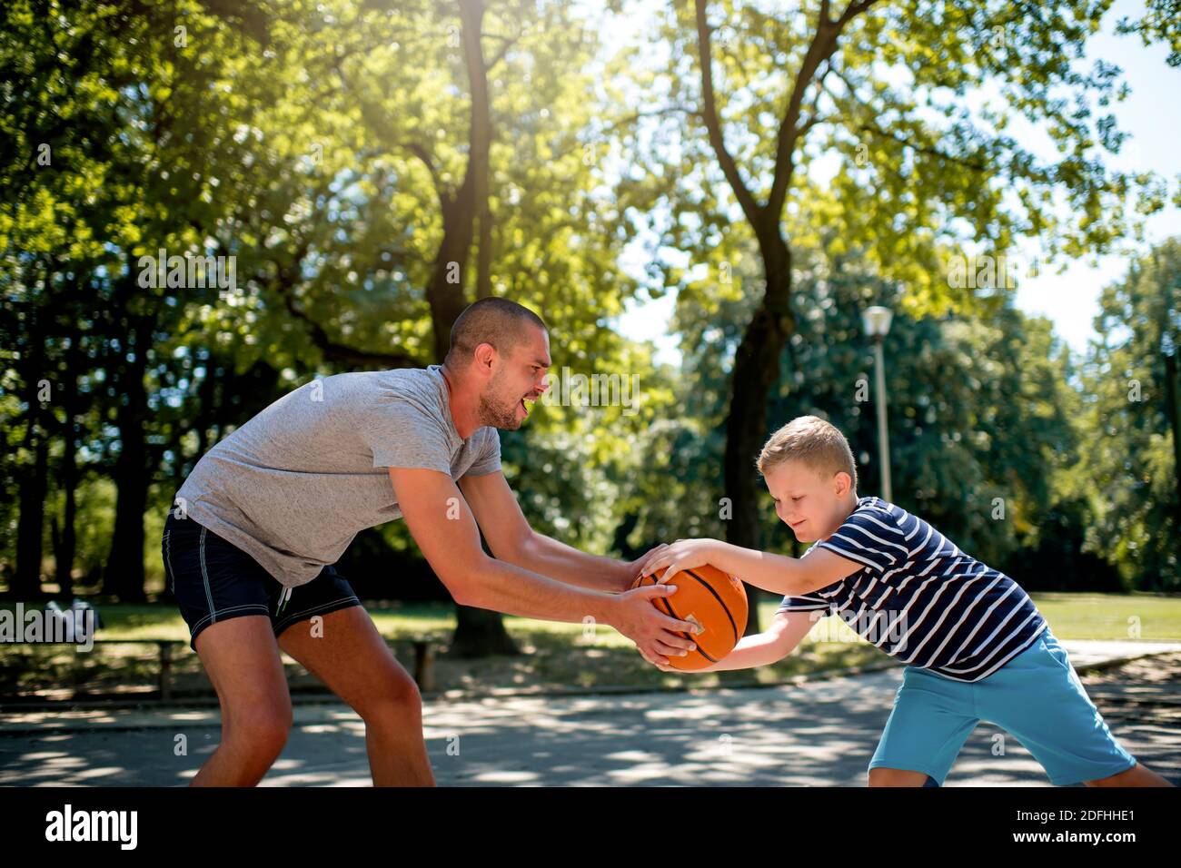Cute blond boy practicing basketball with his coach Stock Photo - Alamy