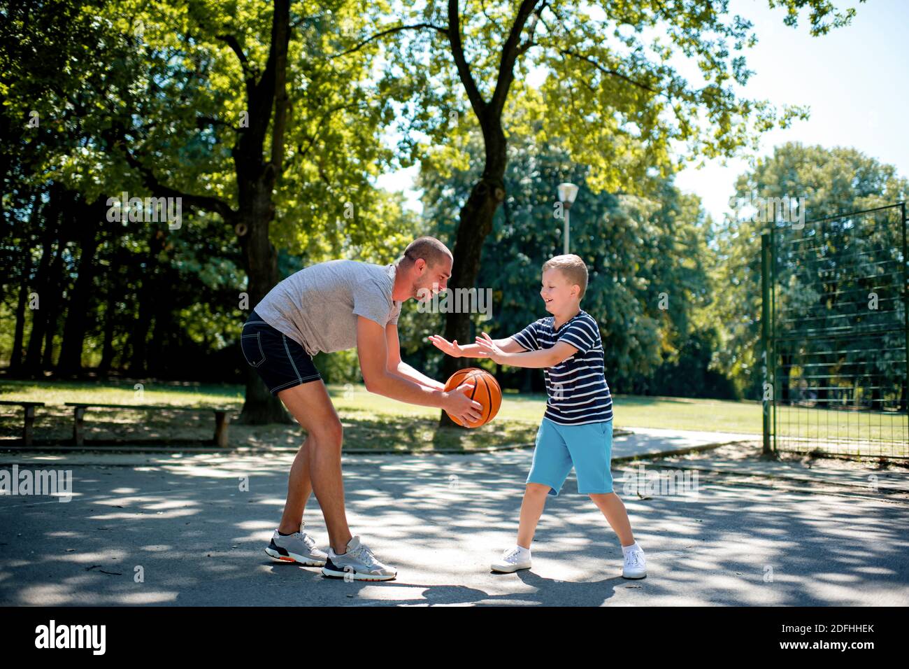 Cute blond boy practicing basketball with his coach Stock Photo - Alamy