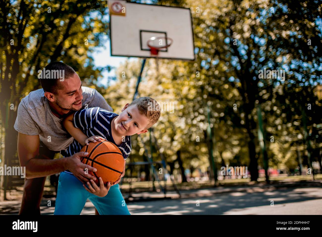 Cute blond boy practicing basketball with his coach Stock Photo - Alamy