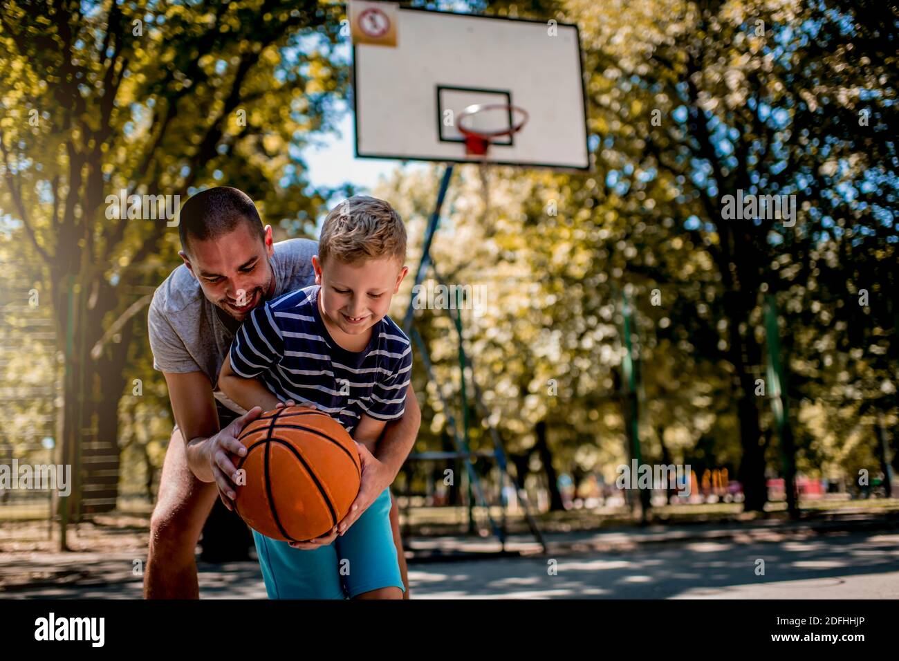 Cute blond boy practicing basketball with his coach Stock Photo - Alamy