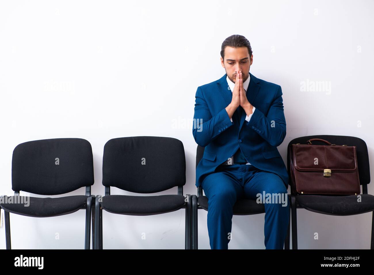 Businessman waiting for an interview at hall Stock Photo - Alamy