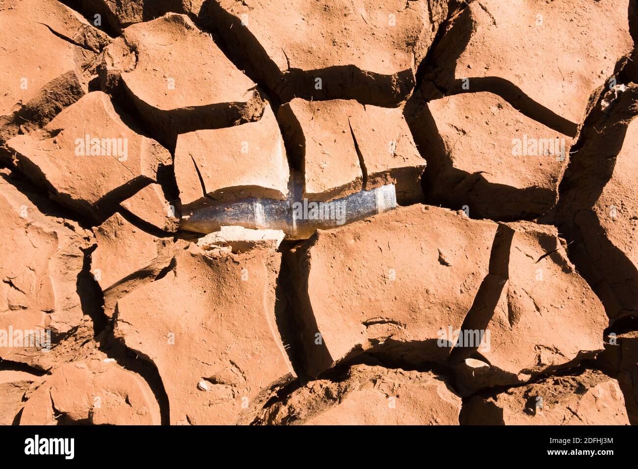 Old glass bottle partially buried in an arid soil in the bottom of a ...