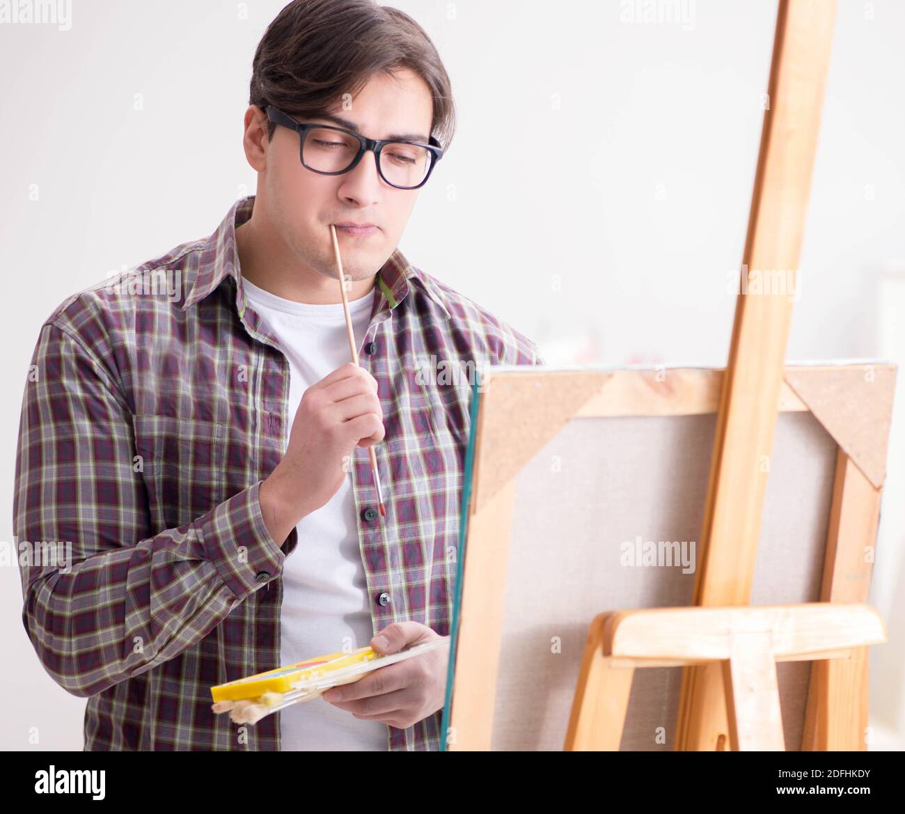 The young male artist drawing pictures in bright studio Stock Photo - Alamy