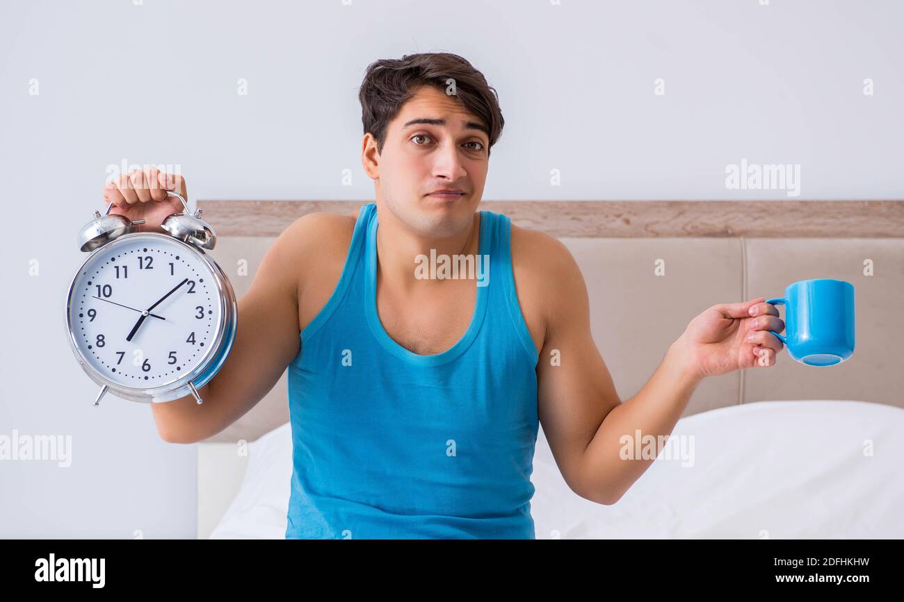 The young man waking up in bed Stock Photo - Alamy