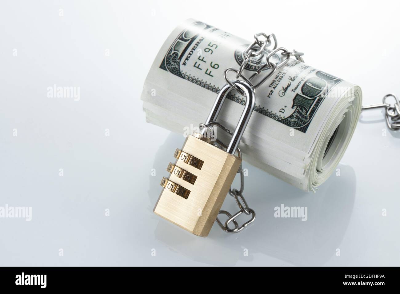 A high angle shot of a stack of dollar bills chained and locked with a ...
