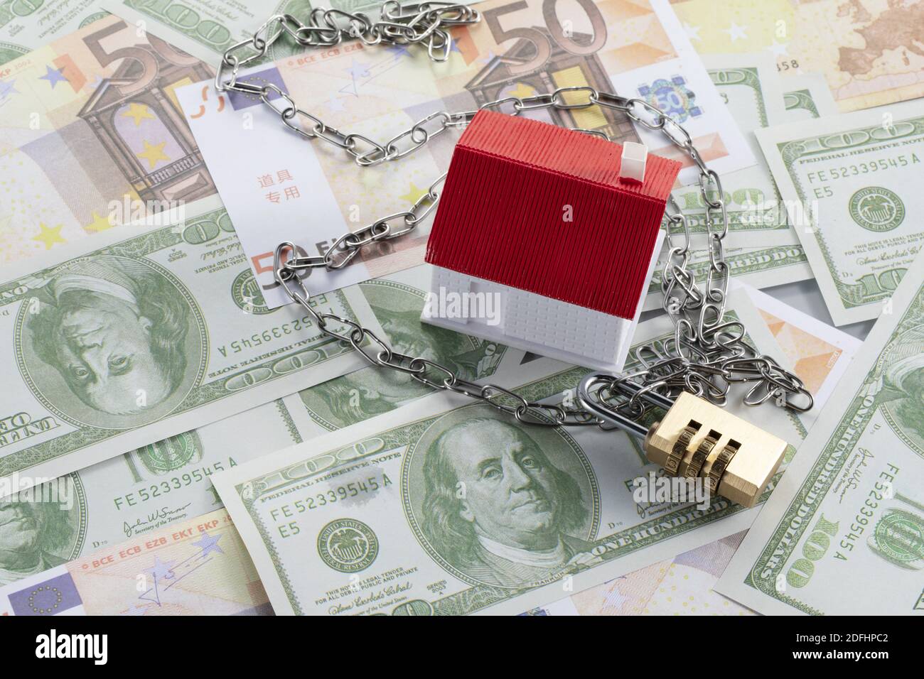 A high angle shot of dollar bills and a chain and a padlock - Saving ...