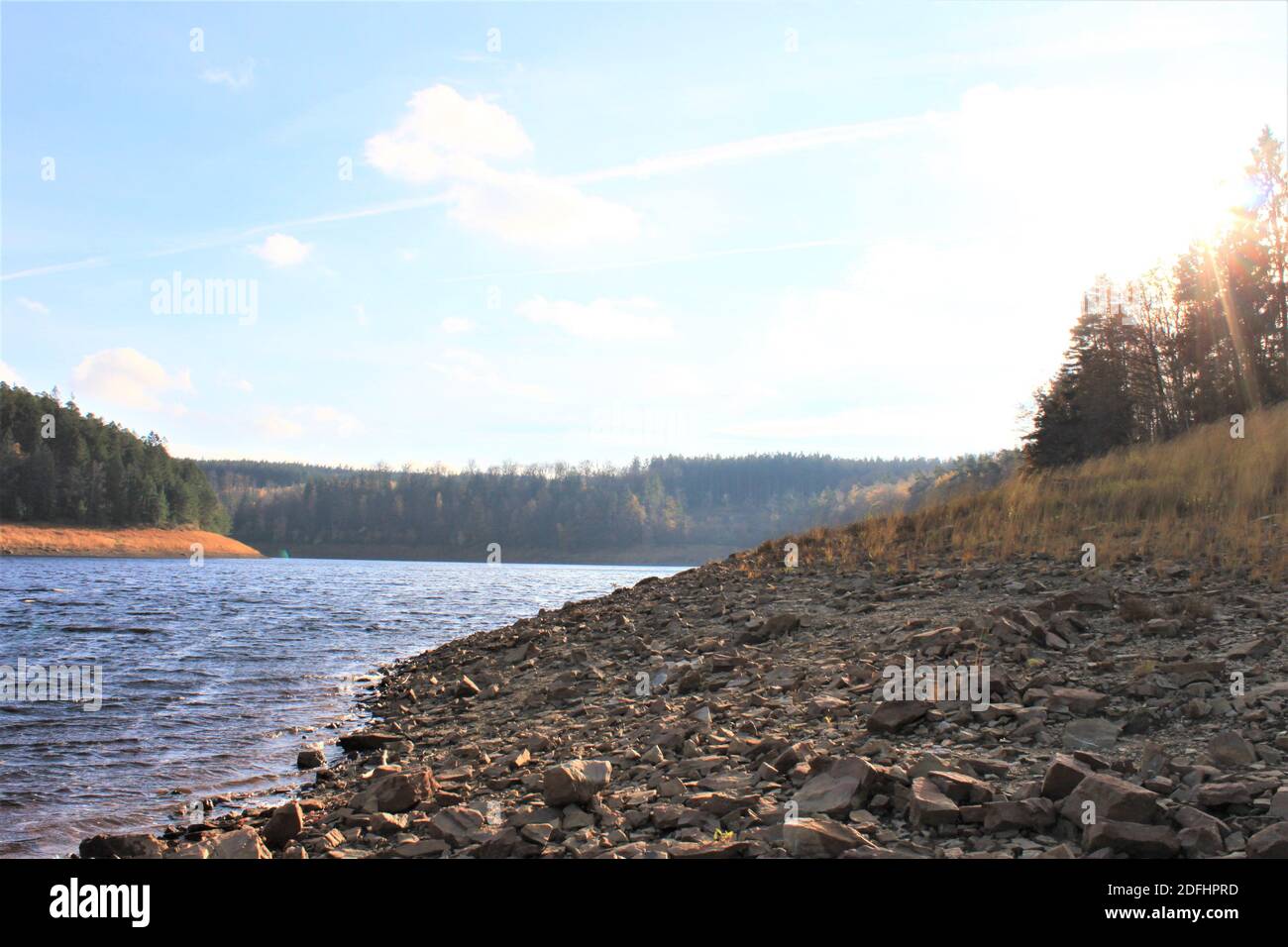 A scenic view of a rocky shoreline with autumn landscape Stock Photo ...