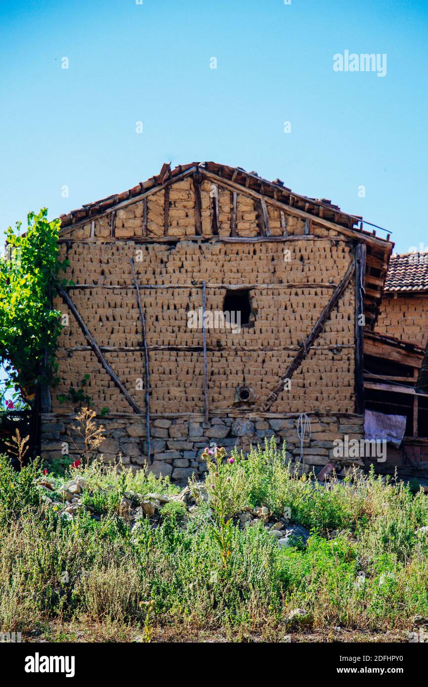 A vertical shot of a wooden barn with a roof in the garden with trees ...