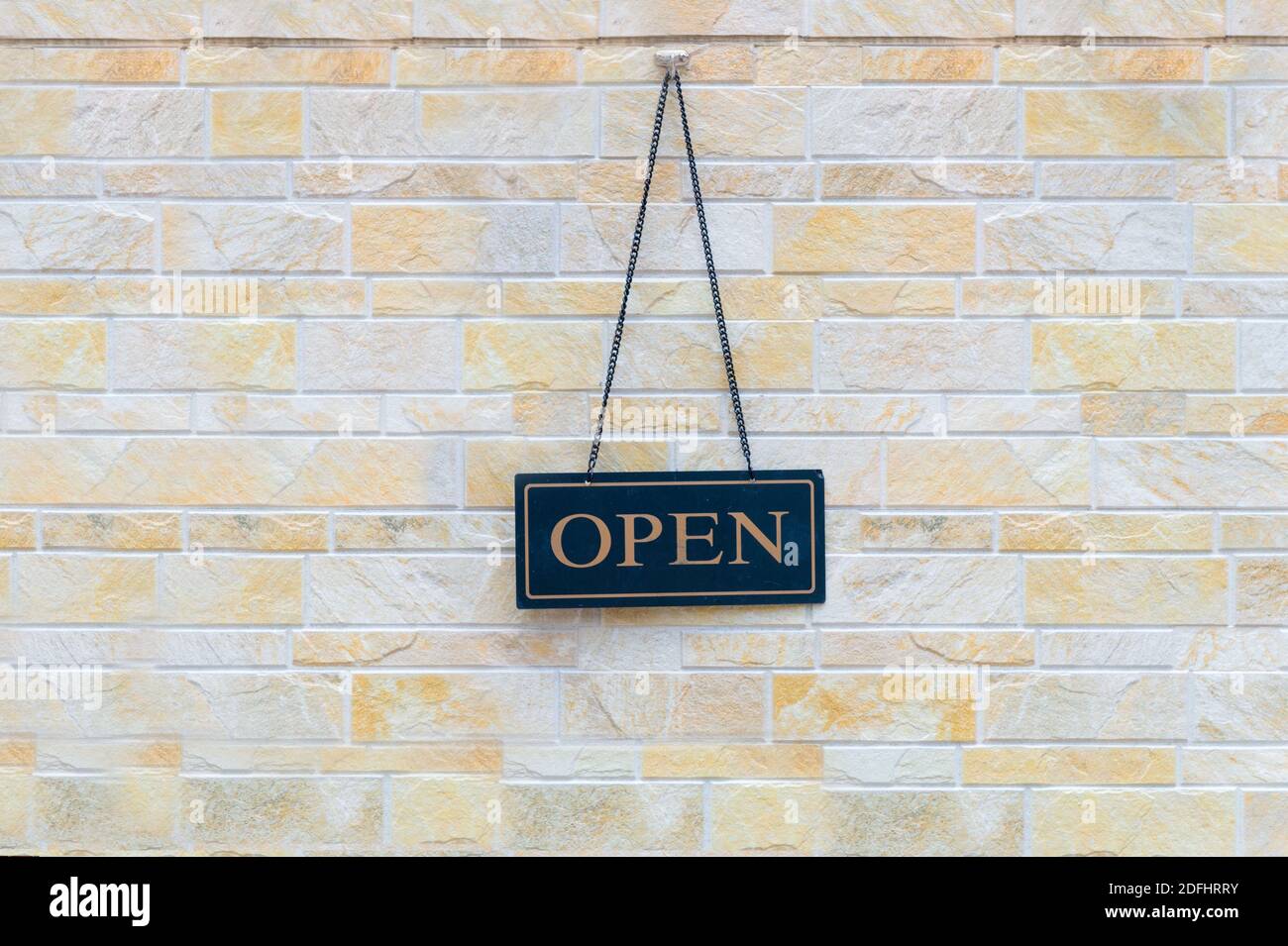 Open Sign Hanging on a Brick Wall Stock Photo - Alamy