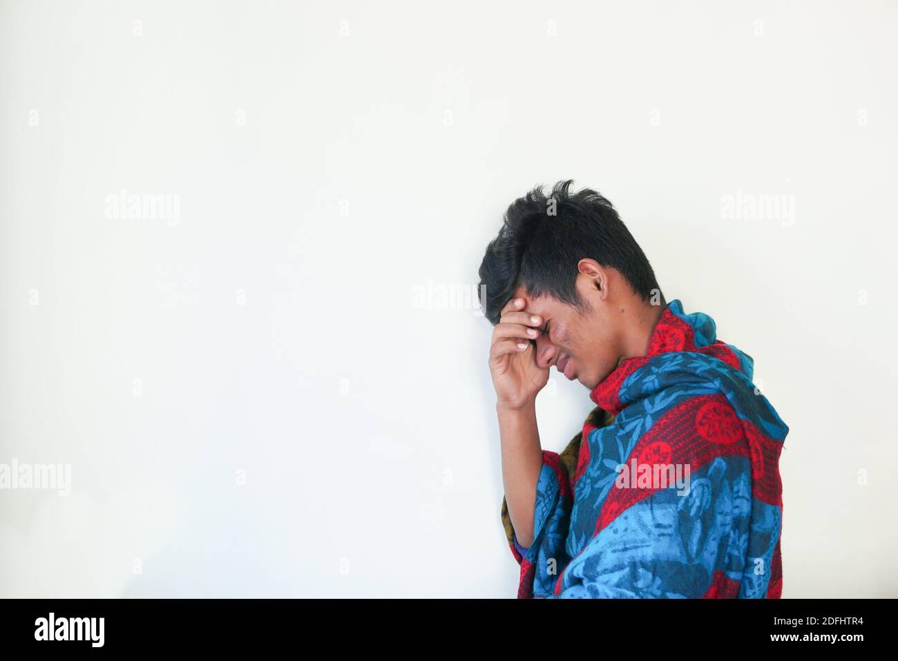 young sick man coughing against white wall Stock Photo - Alamy