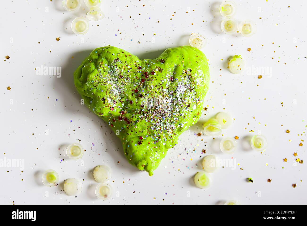 Green heart with shiny glitters made from slime by child Stock Photo ...