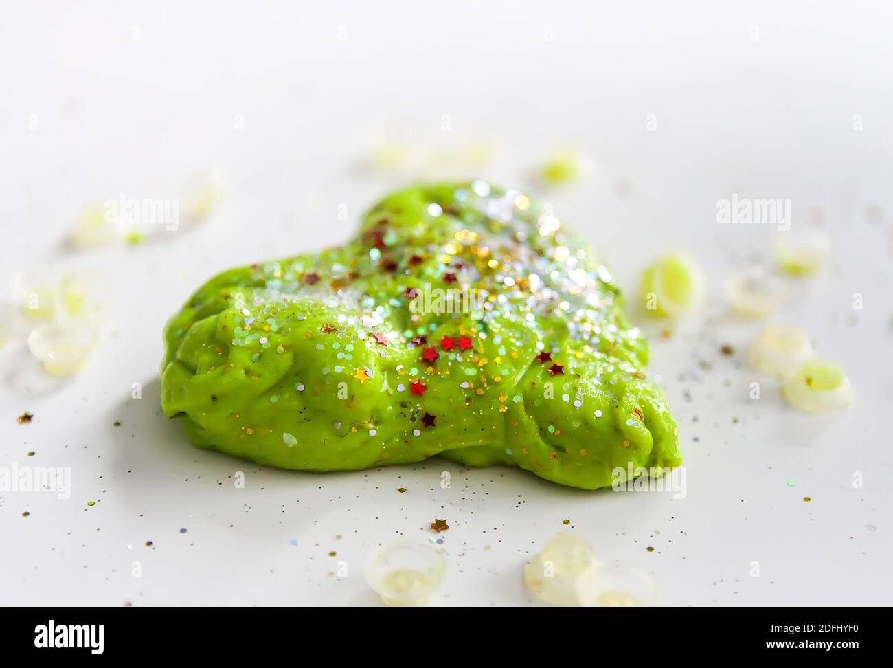 Green heart with shiny glitters made from slime by child Stock Photo ...