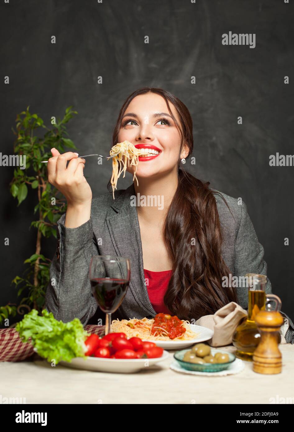 Happy woman enjoying pasta in restaurant Stock Photo - Alamy