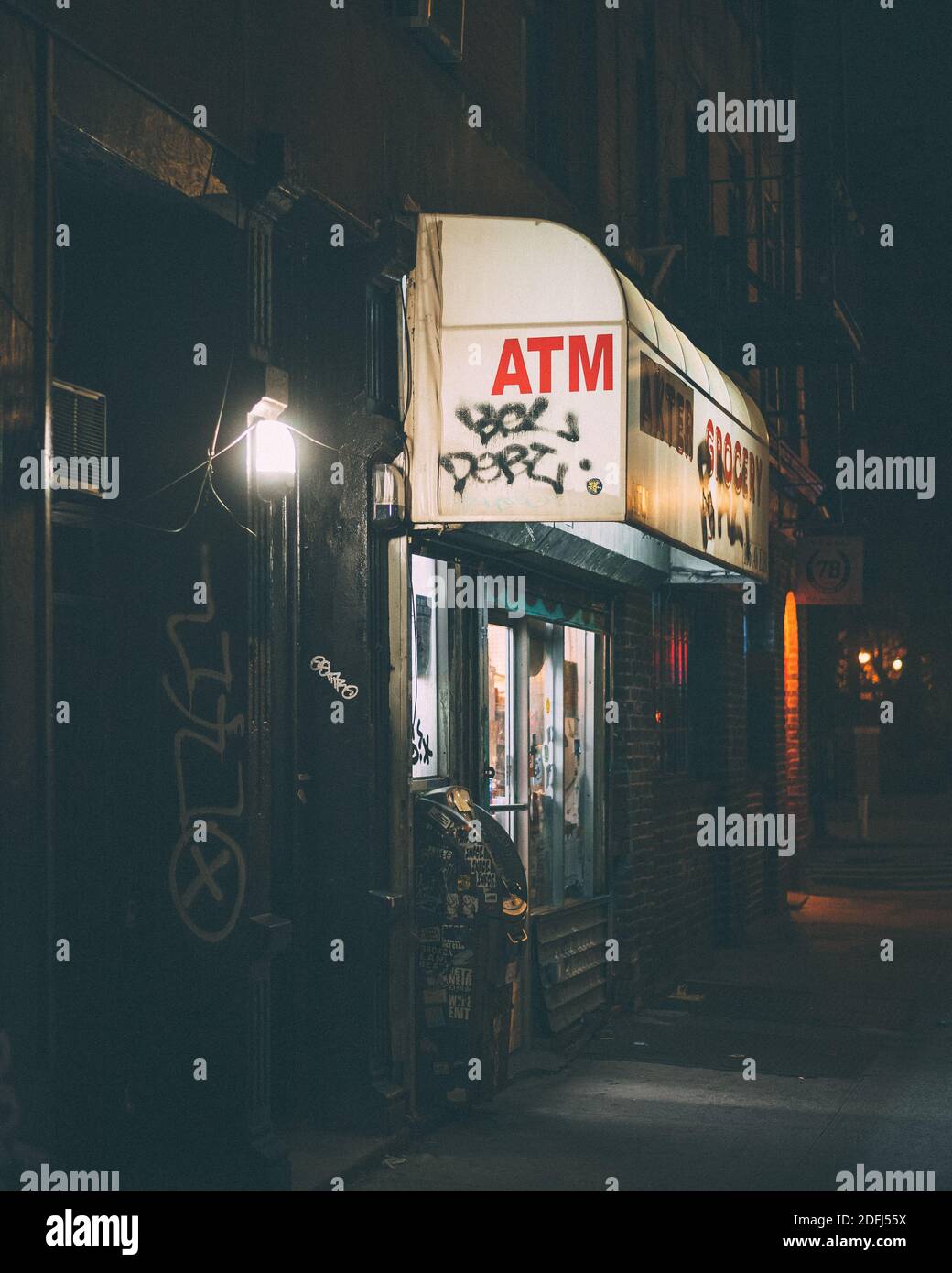 ATM sign and corner store at night in the East Village, Manhattan, New ...