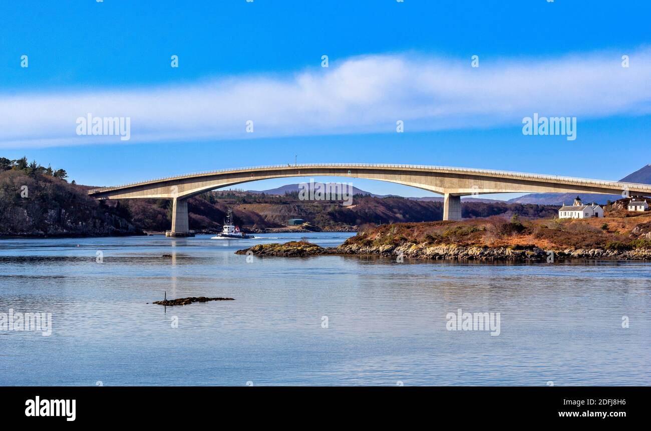 SKYE BRIDGE OVER A SMALL TUG BOAT AND EILEAN BAN [WHITE ISLAND] WITH ...