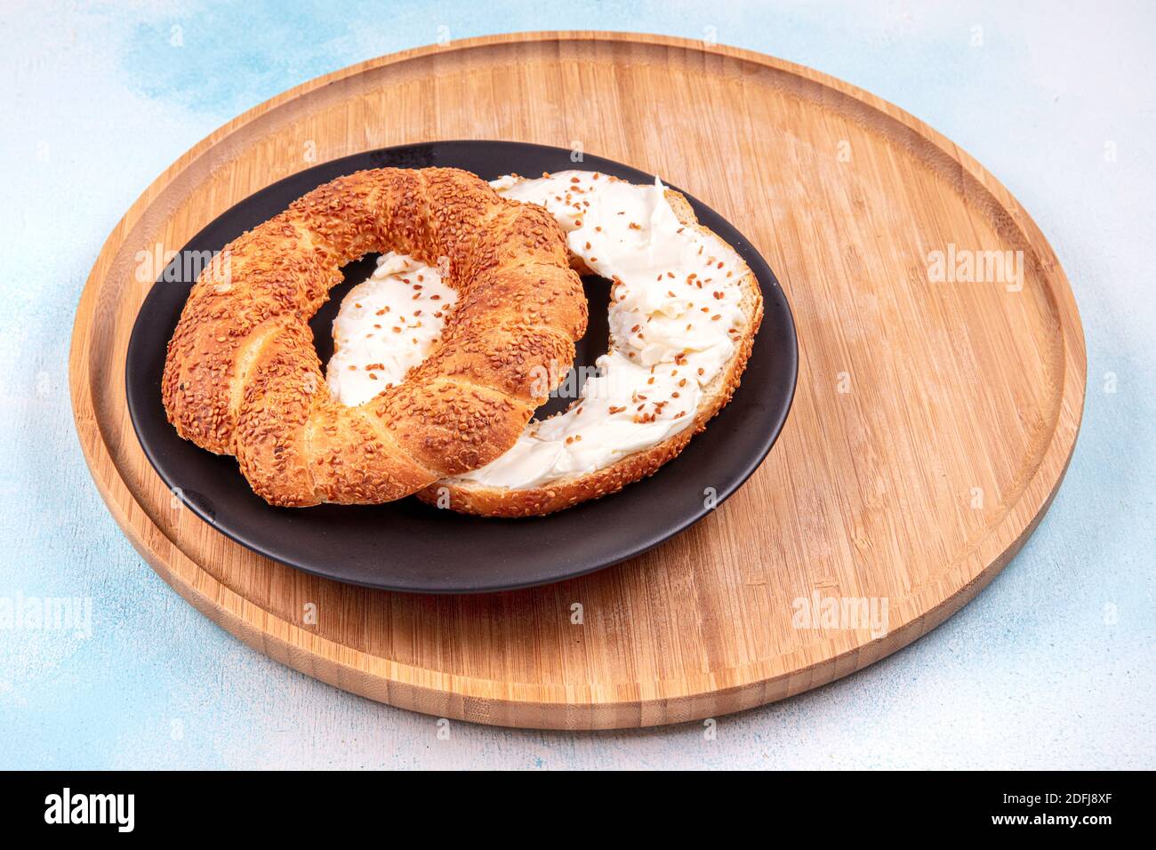 Turkish bagel (Simit) sesame with spread cream cheese close-up on a ...