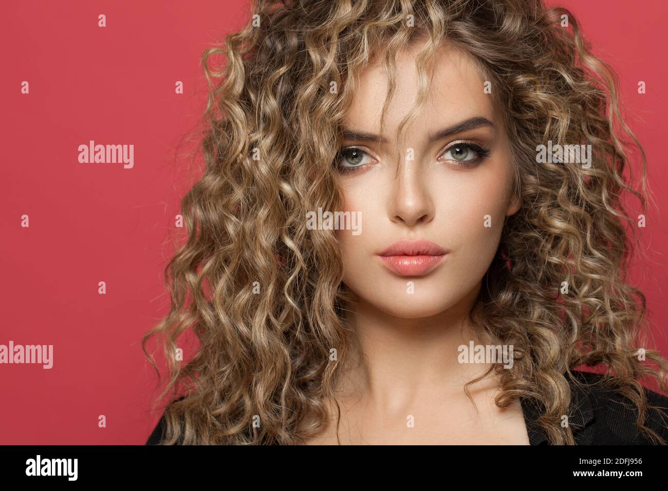 Beautiful woman face. Perfect female model with curly hair on red ...
