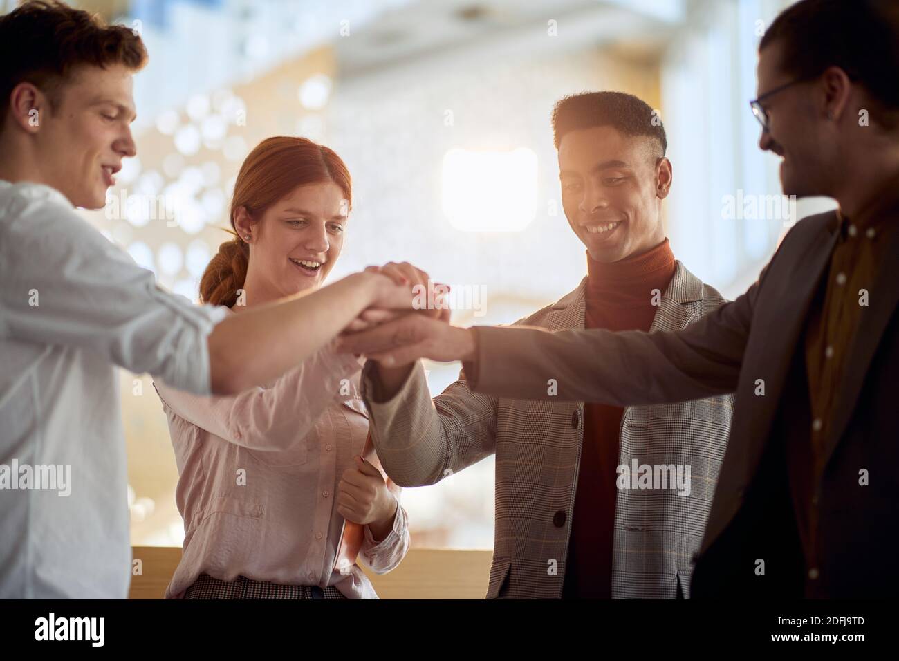 A group of employees building up spirit of togetherness in a pleasant ...