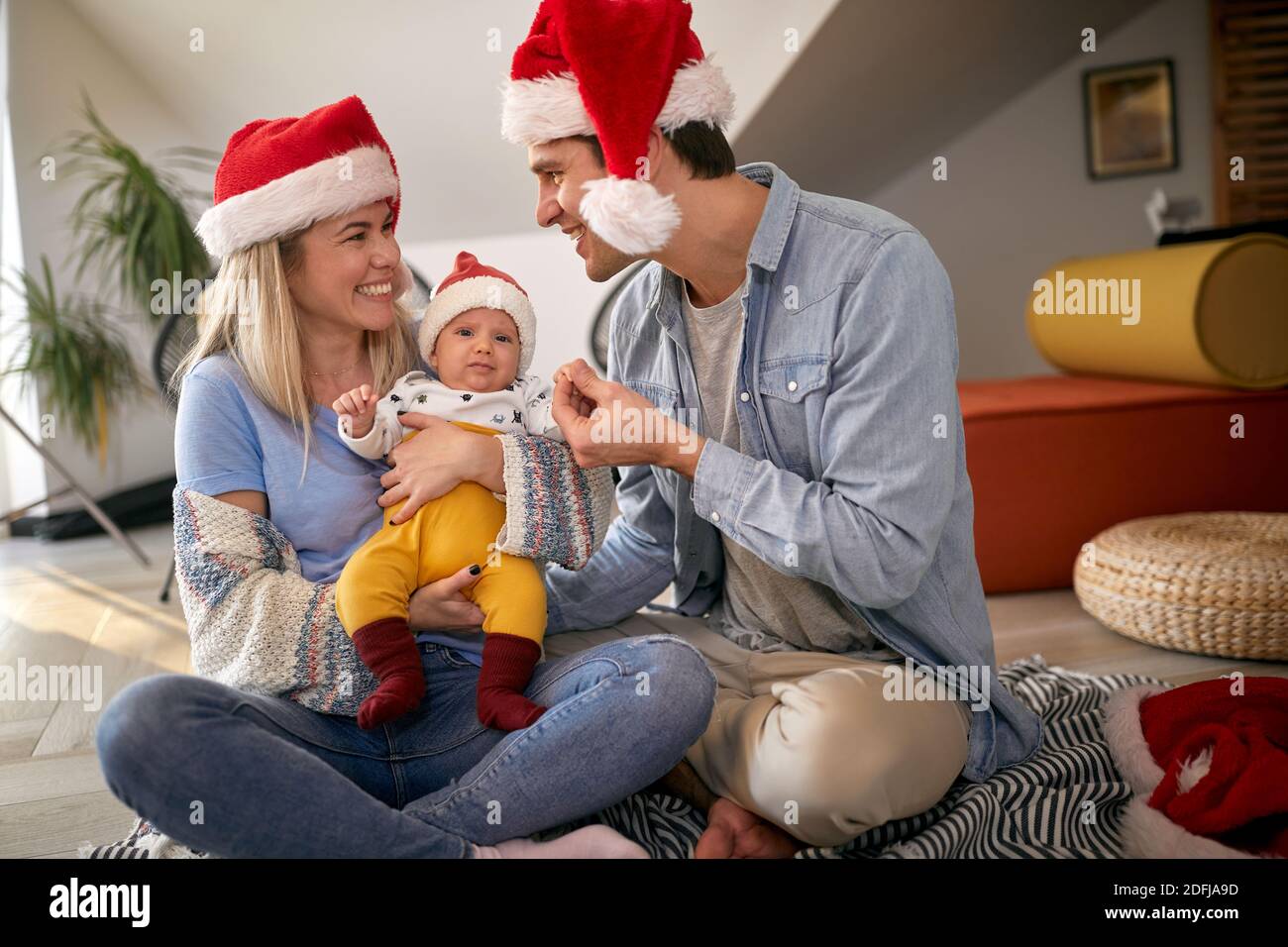 Young parents in lovely moments with their baby on New Year's eve in a ...