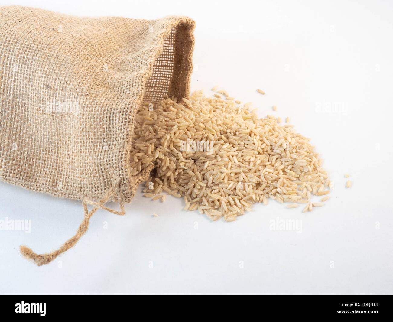 Brown rice coming out of a jute bag. Concept around consumption and ...
