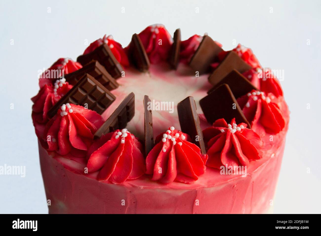 Cherry mousse cake decorated with whipped cream and milk chocolate bars ...