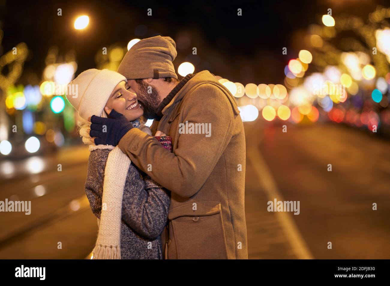 A young couple showing emotions in a walk of the city on a cold night ...
