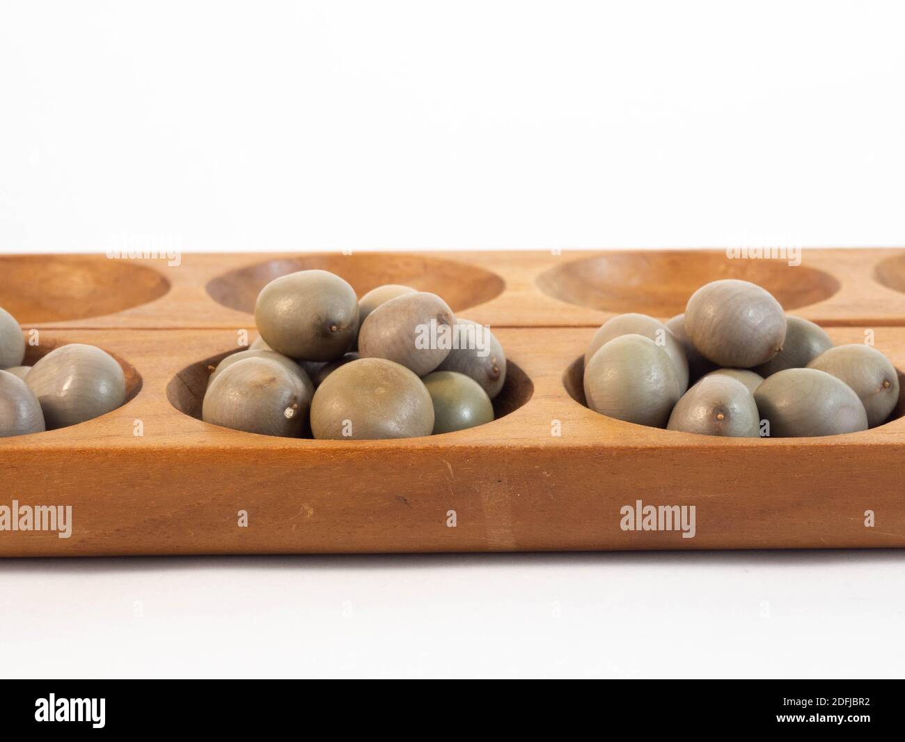 A traditional African wooden game with seeds, the awale. Concept around ...