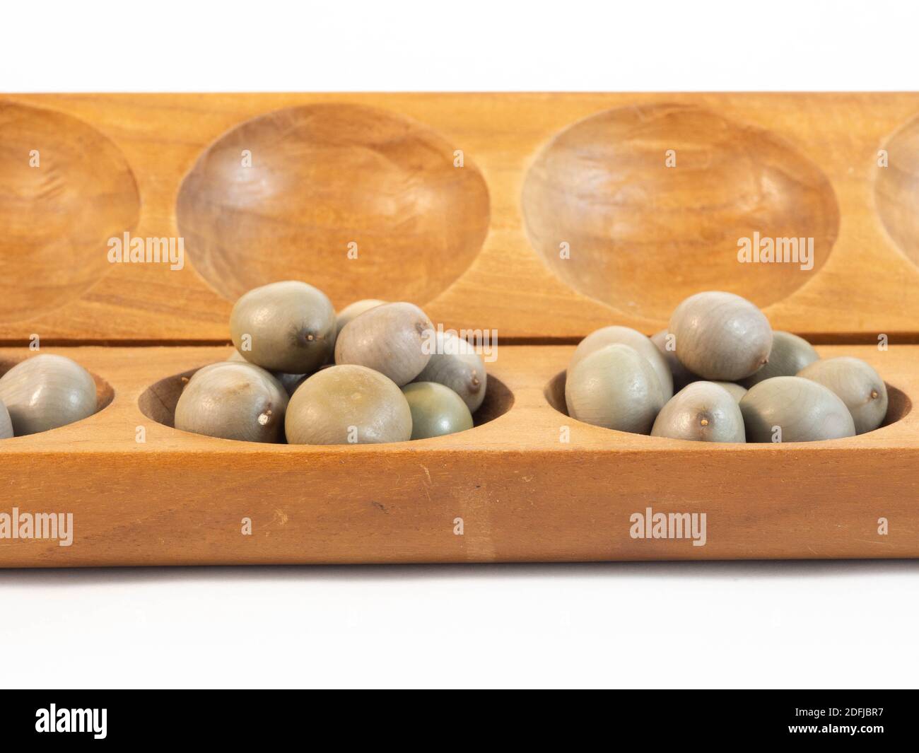 A traditional African wooden game with seeds, the awale. Concept around ...