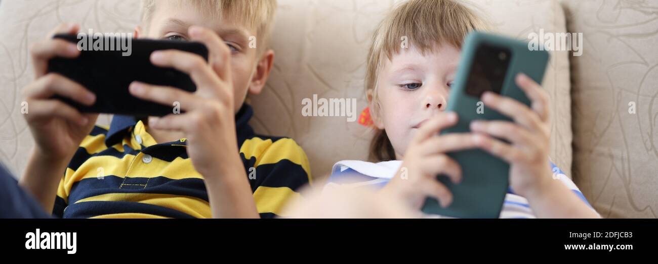 Children hold mobile device in their hands and play Stock Photo - Alamy