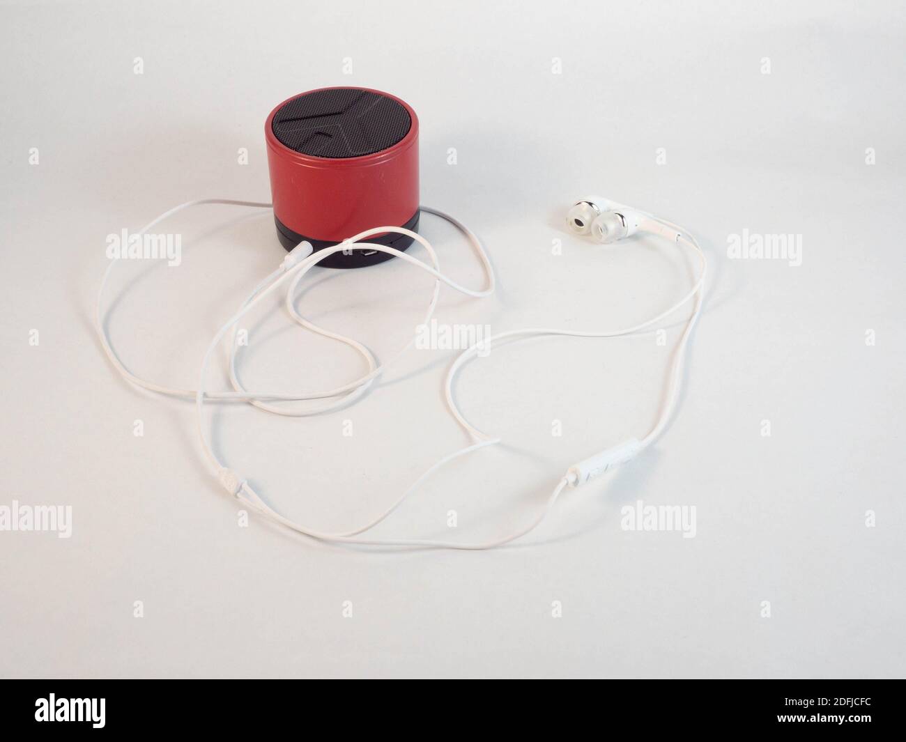 Headphones plugged into a bluetooth speaker. Concept around music ...