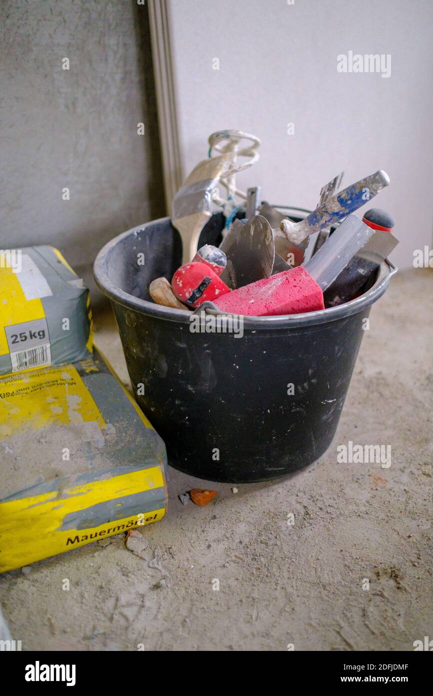 a black bucket full of tools is standing on a construction site Stock ...