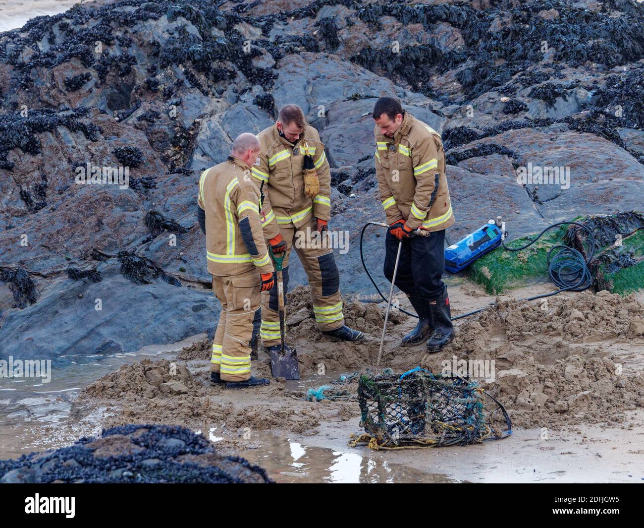 UK Fire Brigade members use lost crab pots buried on beach to practice ...