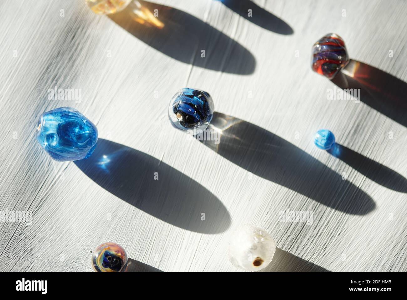 Group of glass beads of various colors and shapes and their long ...