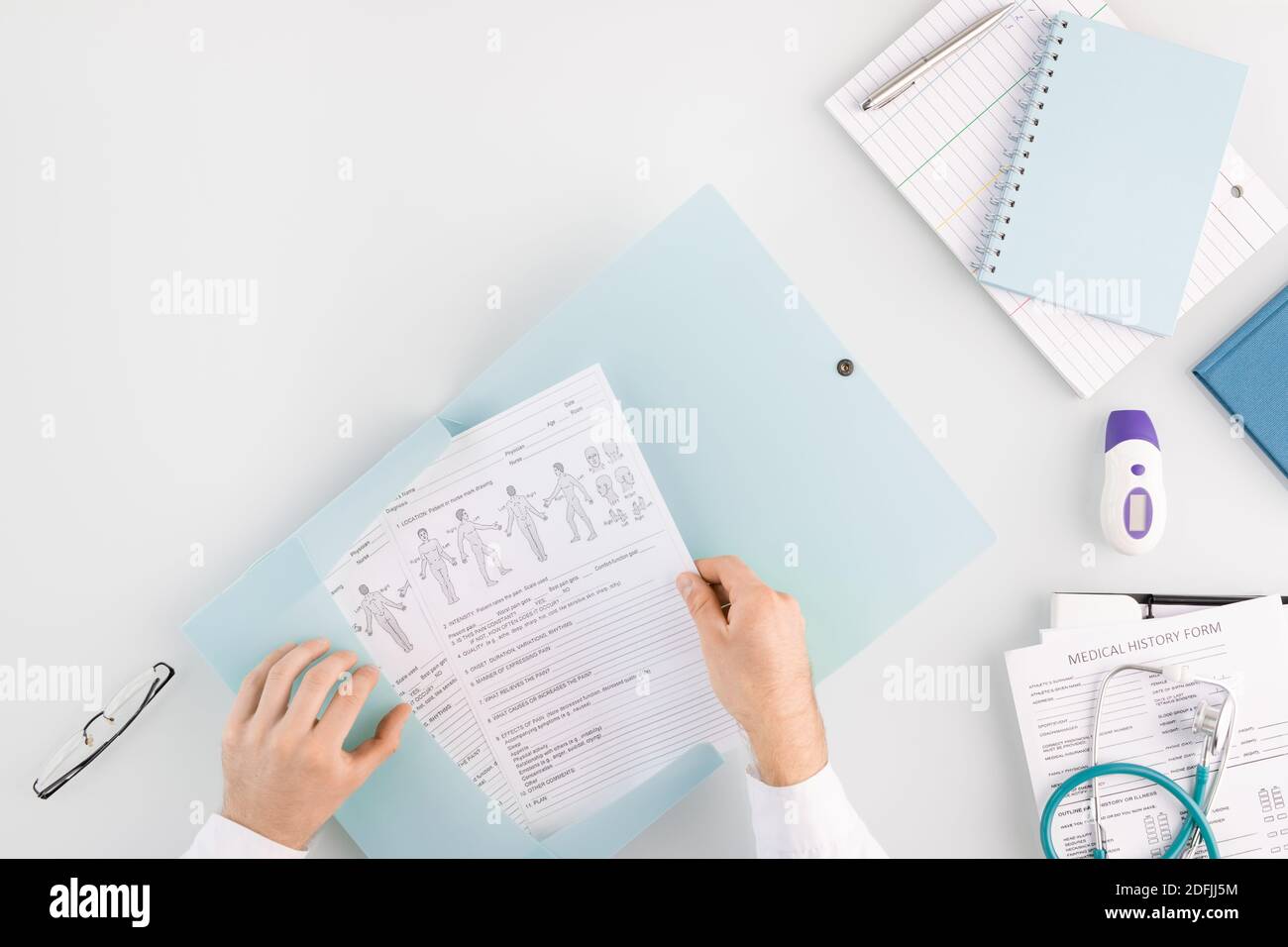 Hands of doctor putting medical document into folder with other files ...