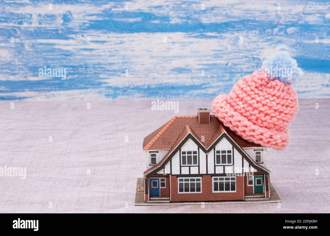 Small model house with a woolen bobble hat on the roof - home ...