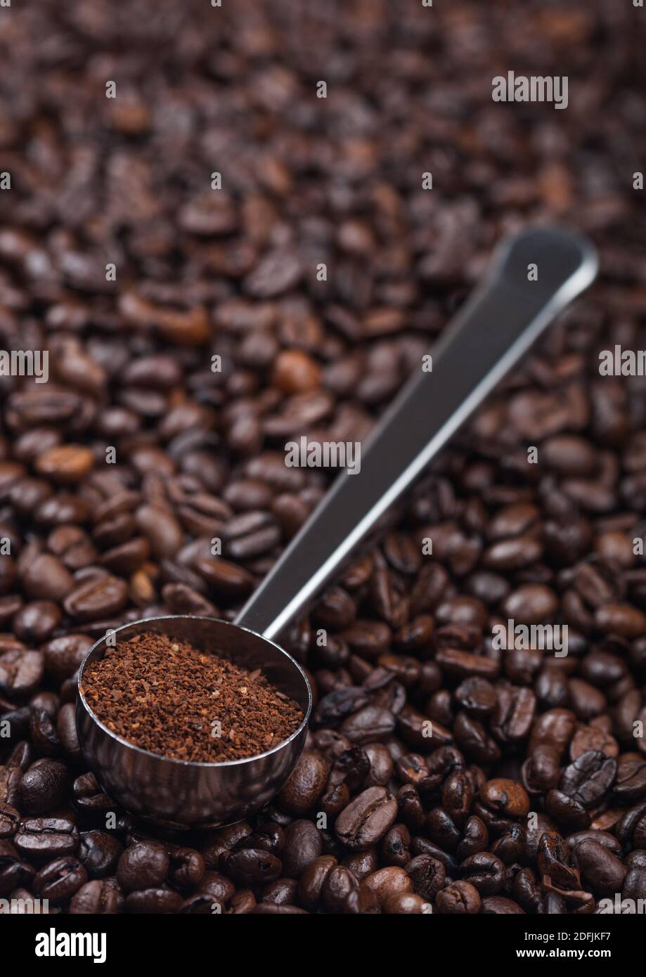 Fresh raw organic ground coffee powder in black steel scoop on top of ...