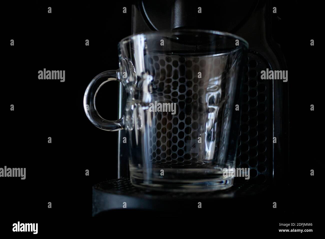 Transparent glass cup in an espresso machine. Concept work, rest. Dark ...