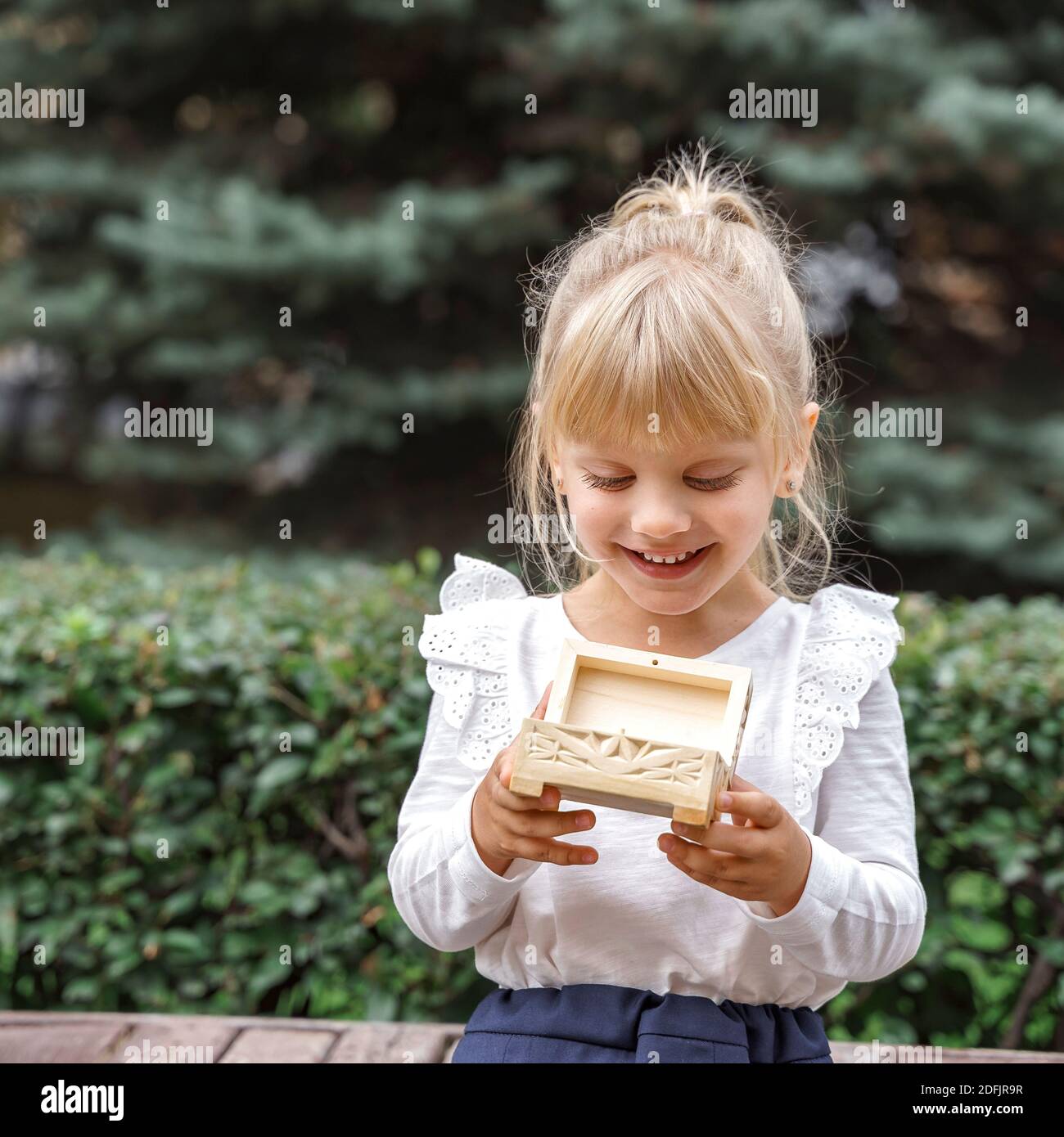 beautiful little girl looks fascinated at a wooden box Stock Photo - Alamy