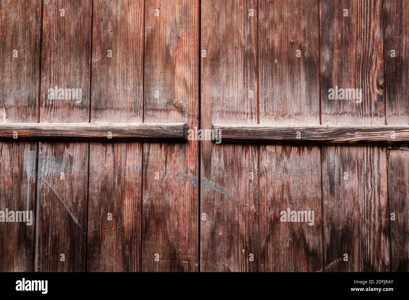 Dark brown weathered wooden plank wall of chalets in the old town of ...