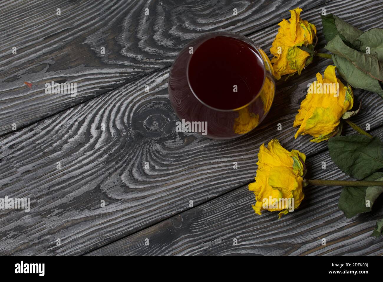 A bouquet of dried yellow roses. An overturned glass of sour wine. On ...
