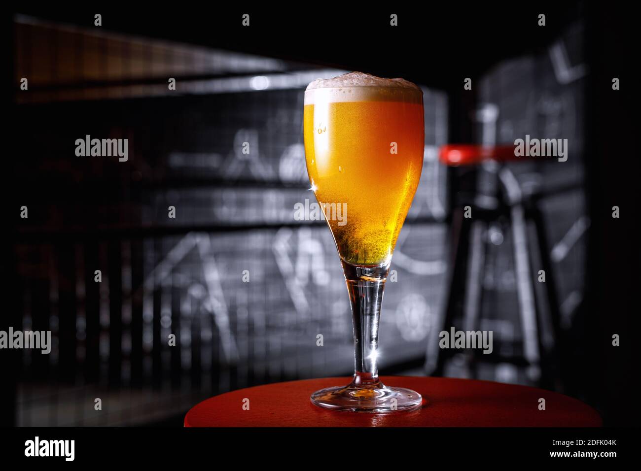 A glass of blond beer on a thin leg in a bar Stock Photo - Alamy