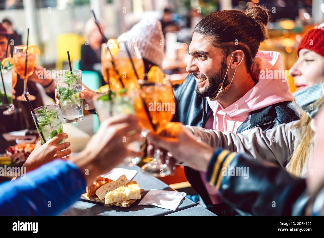 Drunks friends toasting fancy drinks at night bar with open mask - New ...