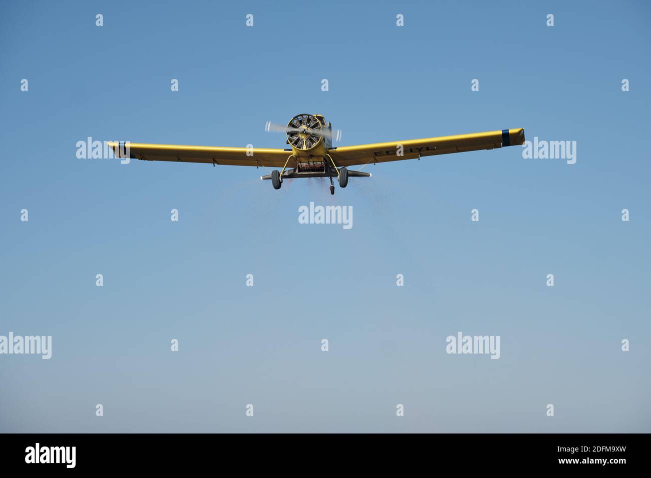 A single-engine propeller airplane flying in a perfectly clear blue sky ...