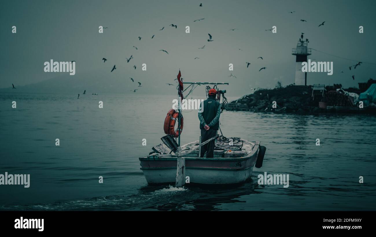 A majestic back view of a fisherman in a boat sailing having an amazing ...
