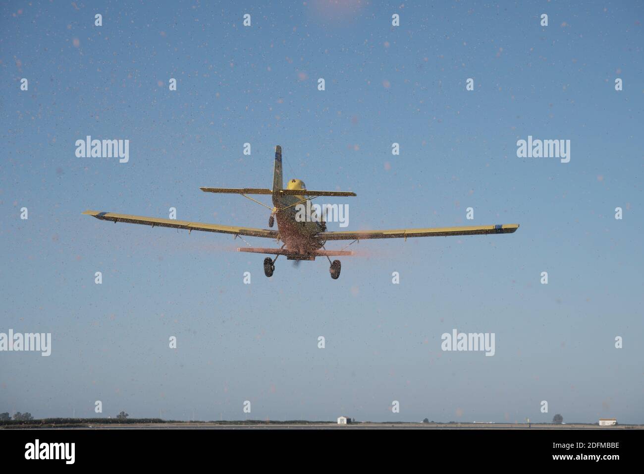 A single-engine propeller airplane flying in a perfectly clear blue sky ...