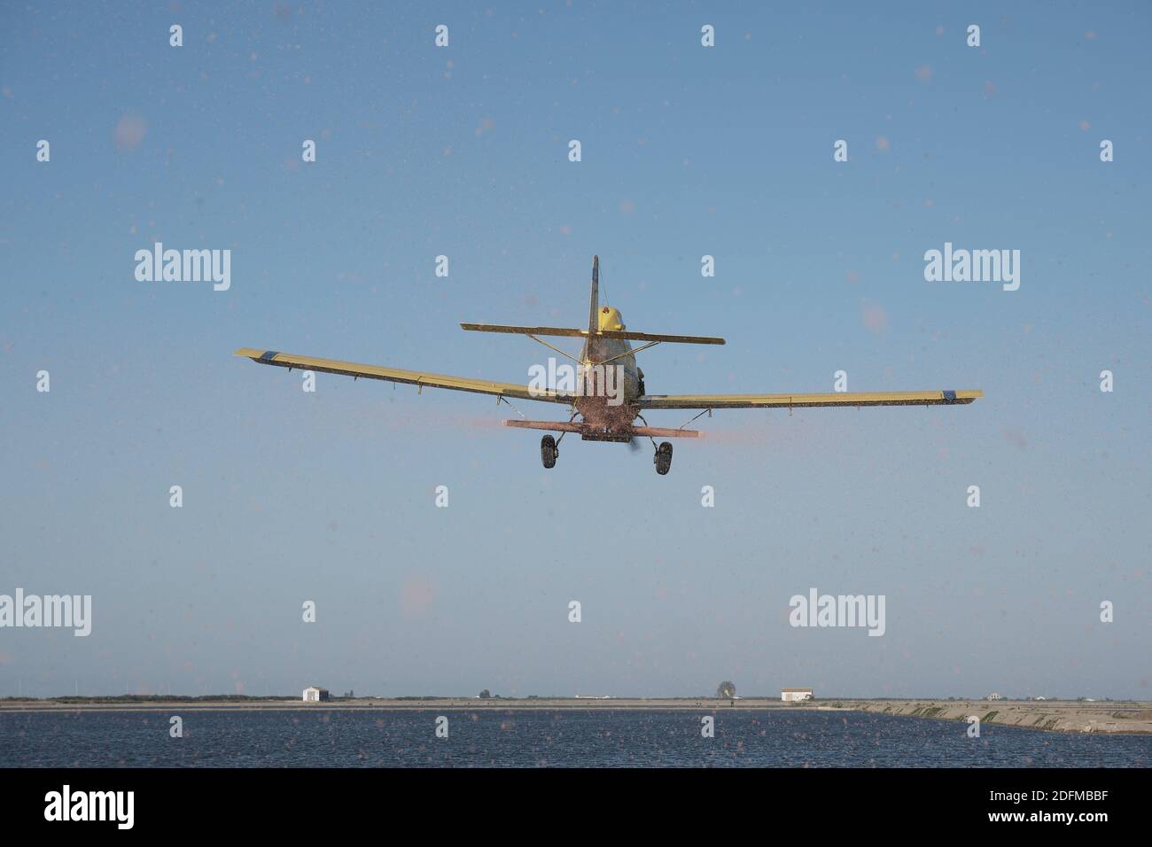 A single-engine propeller airplane flying in a perfectly clear blue sky ...